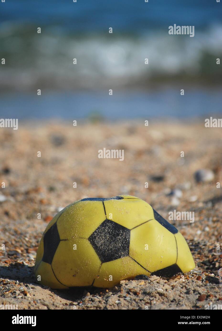 Burst football on a beach Stock Photo - Alamy