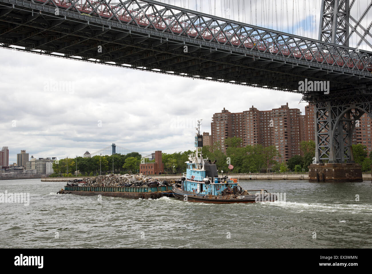 Tug and barge full of scrap metal for recycling on the East River ...