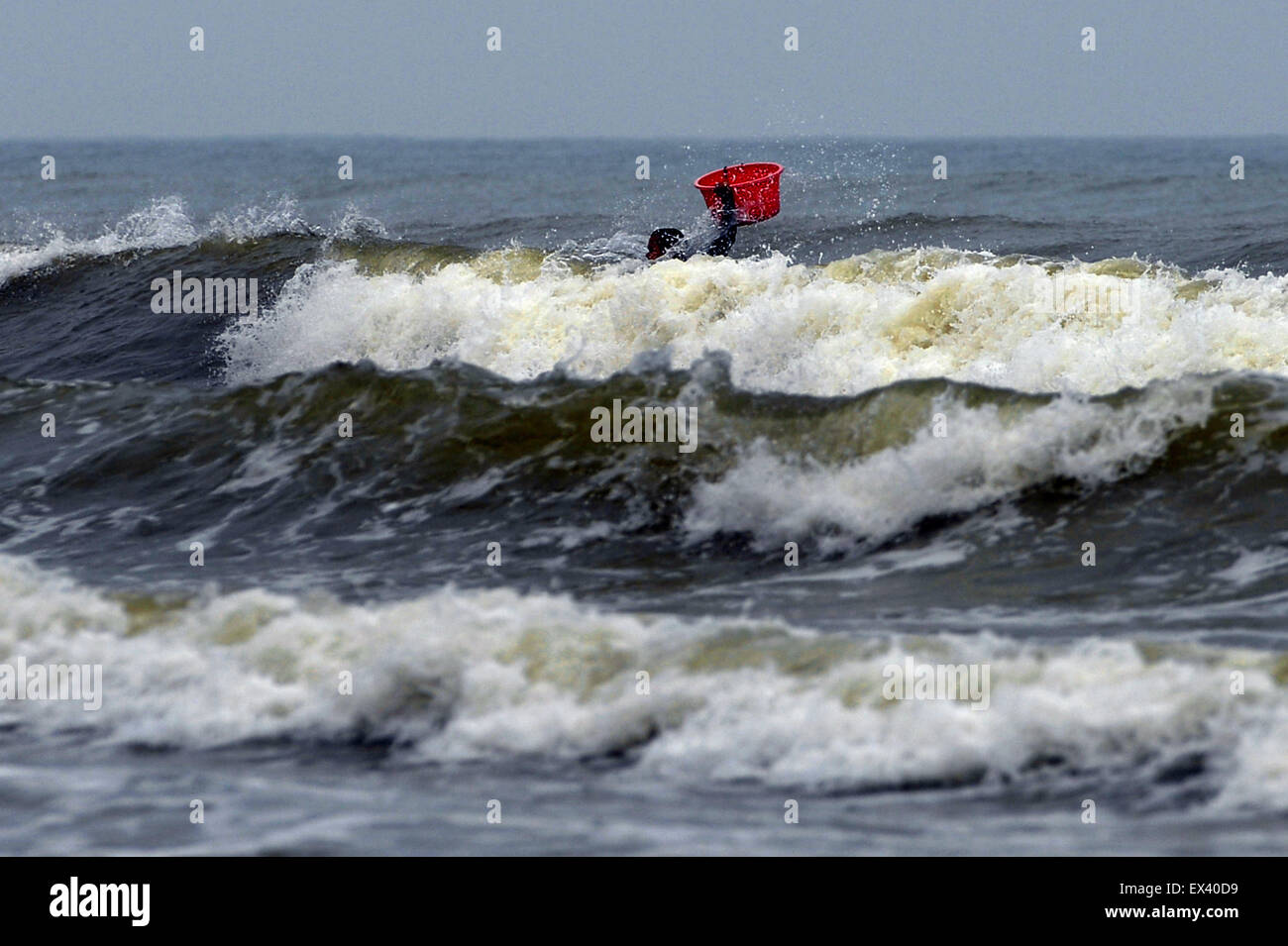 Kota Kinabalu, Malaysia. 6th July, 2015. A fisherman fishes in high ...