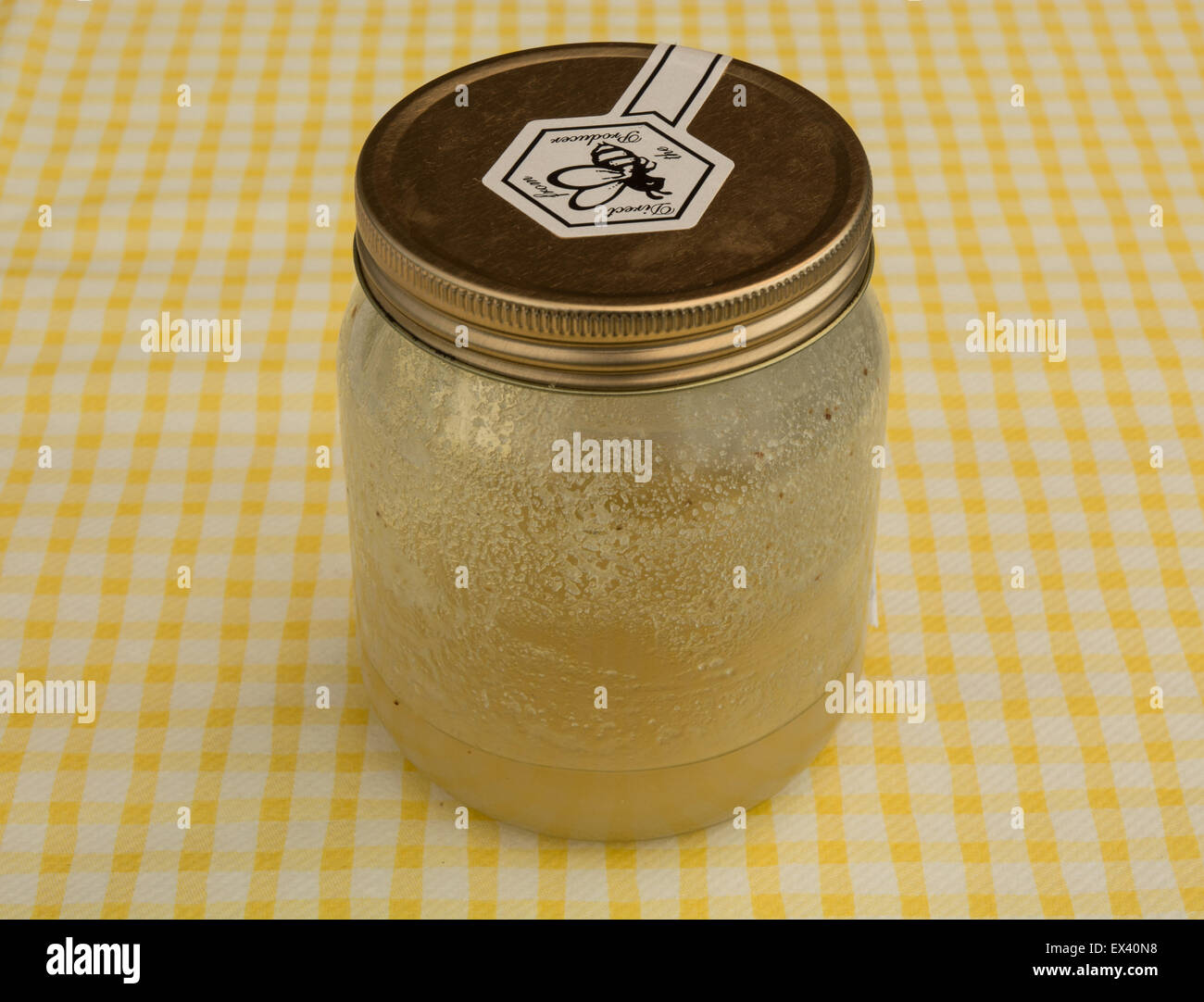 half empty jar of honey on a kitchen table Stock Photo - Alamy