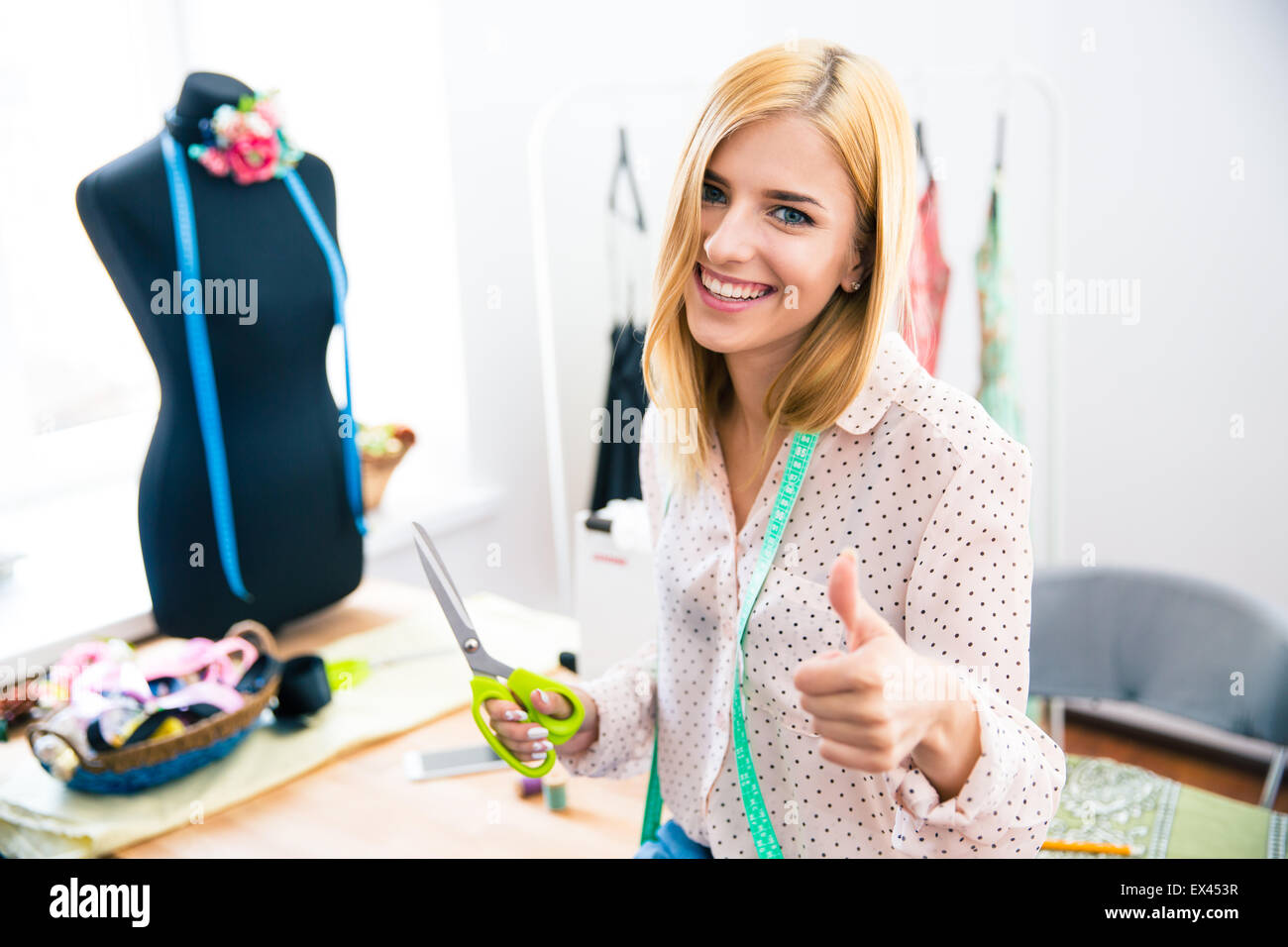 Smiling female tailor standing in workshop and showing thumb up Stock ...