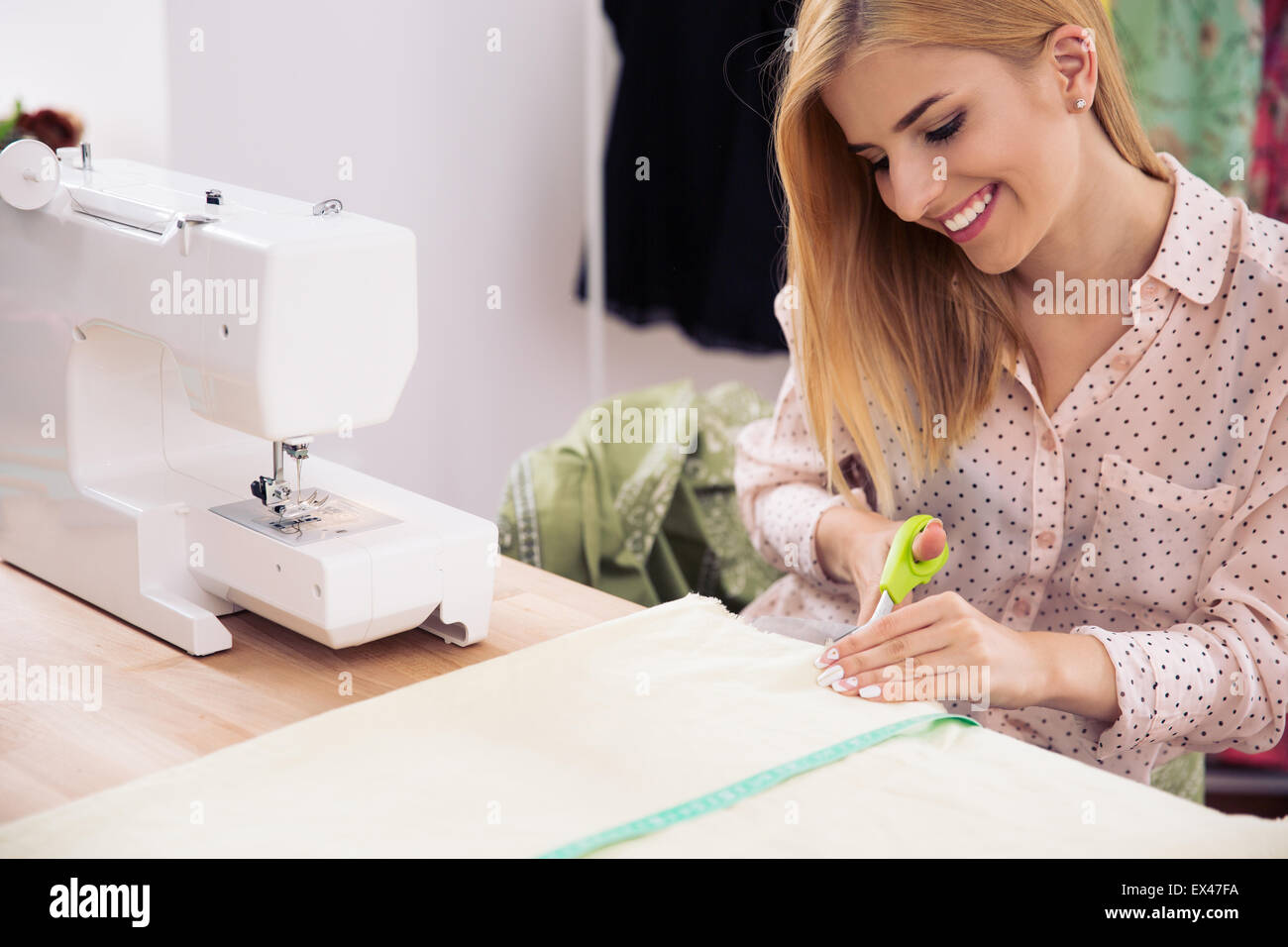 Happy female designer cutting cloth in workshop Stock Photo - Alamy