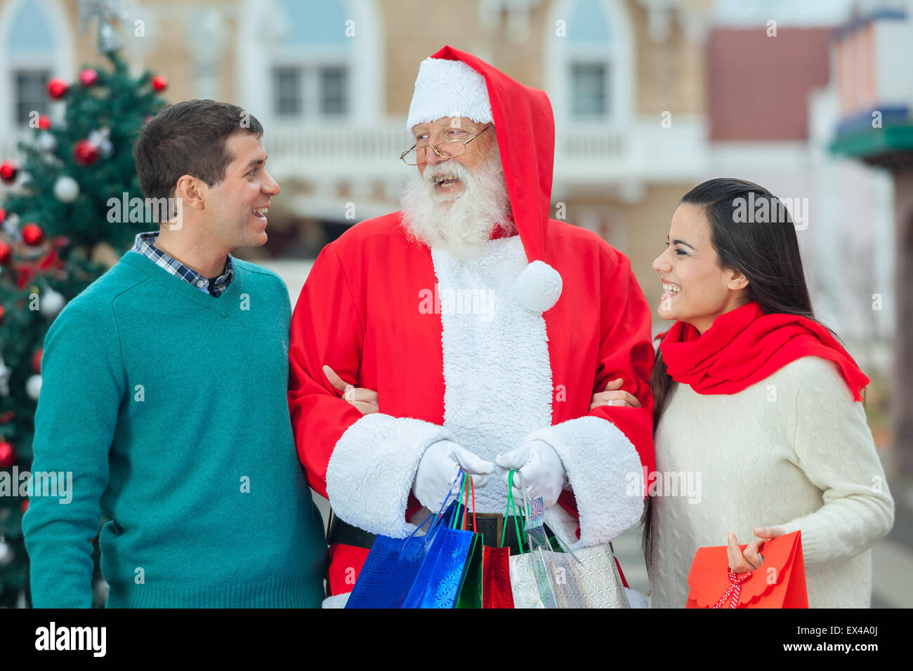 Couple in love talking with Santa Stock Photo - Alamy