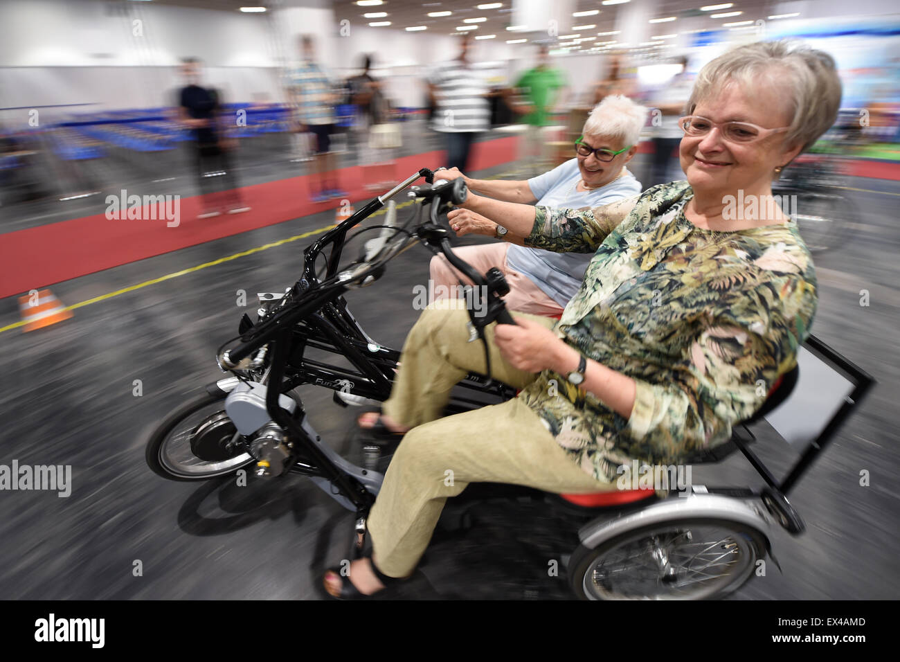 Gunda Krauss (L) and Rosemarie Killius ride a parallel tandem bicycle ...