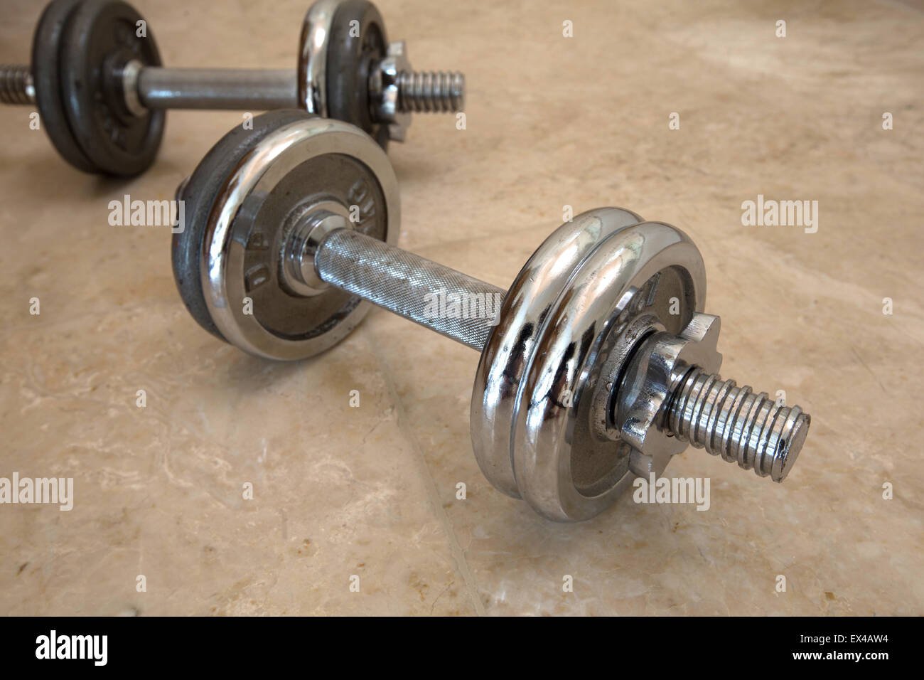 two metal dumbbells lying on the floor Stock Photo - Alamy