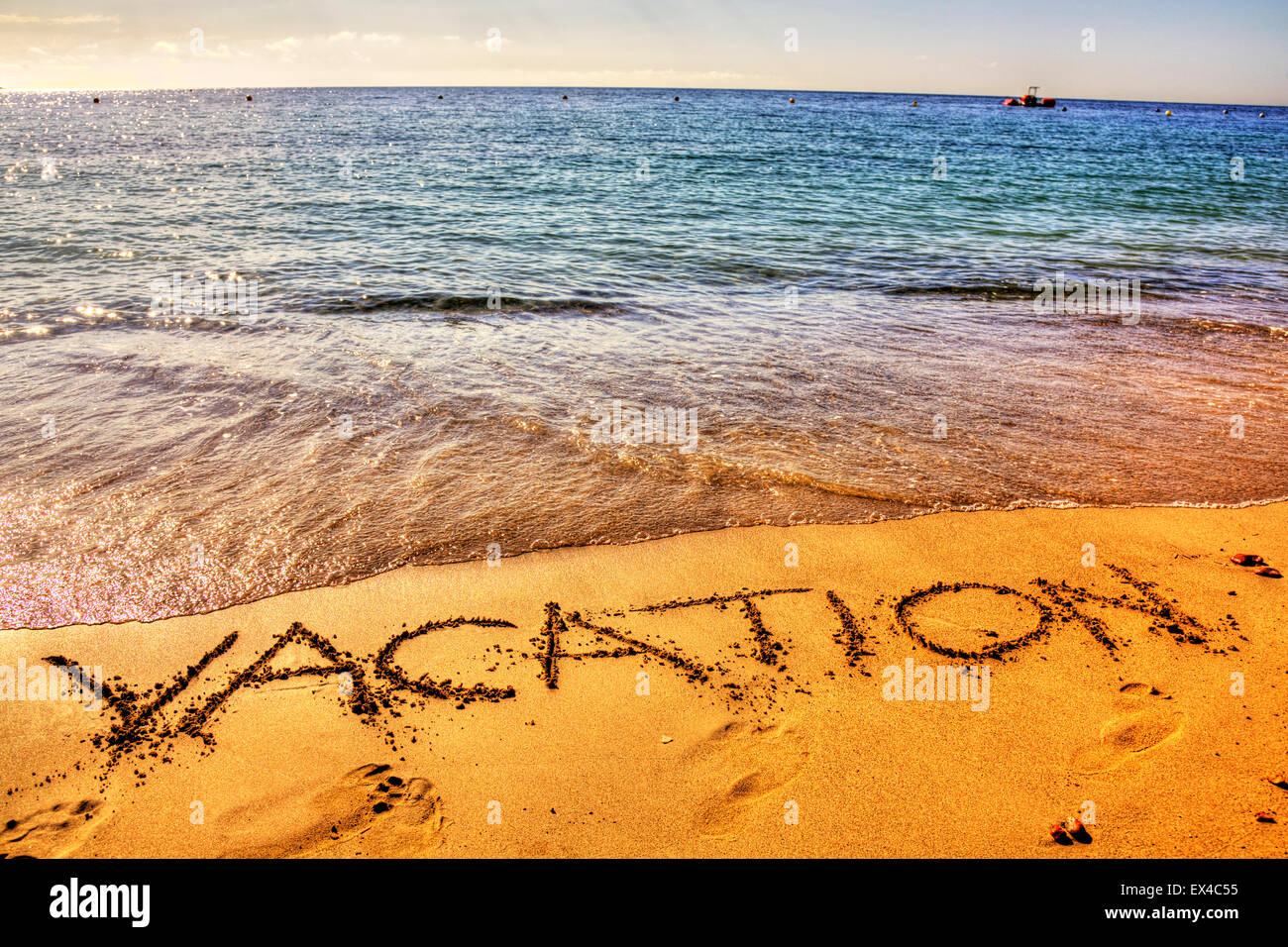 Vacation holiday word in sand written on beach resort sea coast ...