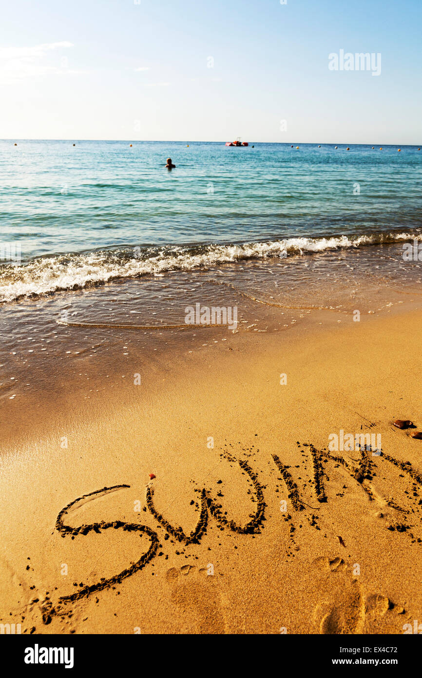 Swim word in sand swimming written on beach Spanish fun resort seas ...