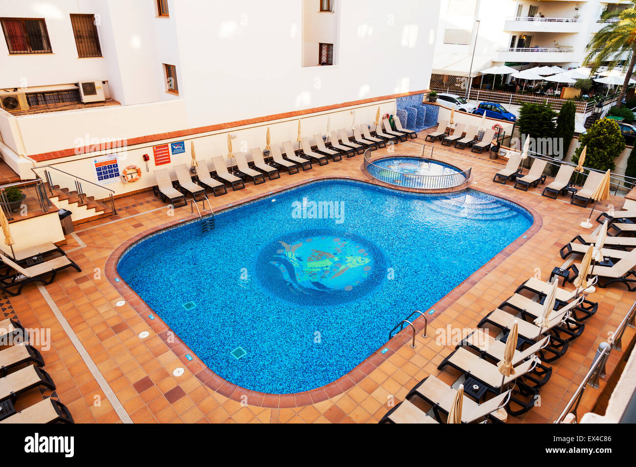 Hotel swimming pool from above sun loungers set out around edge Ibiza ...