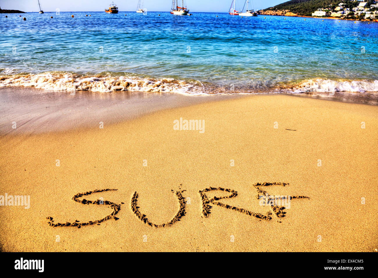 Surf word in sand written on beach Spanish fun resort seas coast ...
