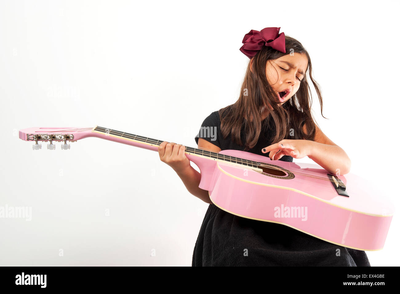 Cute young girl playing guitar and sing Stock Photo - Alamy