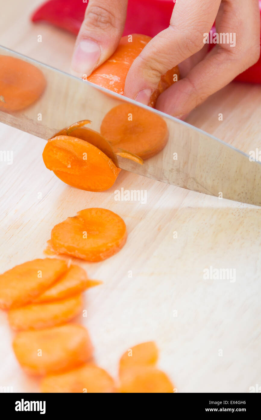 detail of woman hand cutting carrots in kitchen Stock Photo - Alamy