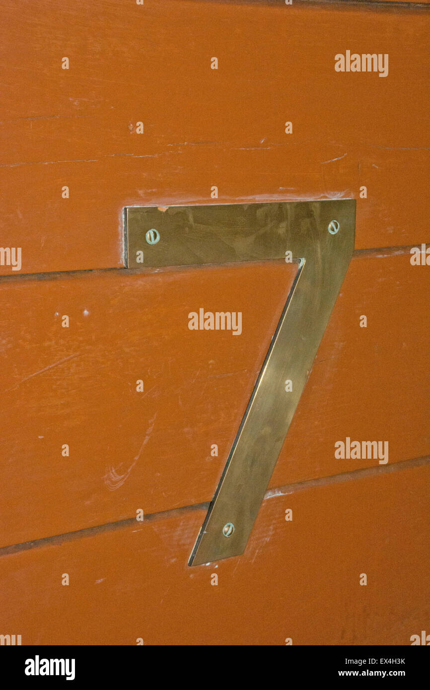Brass plate of a number seven fixed onto wooden planks Stock Photo - Alamy