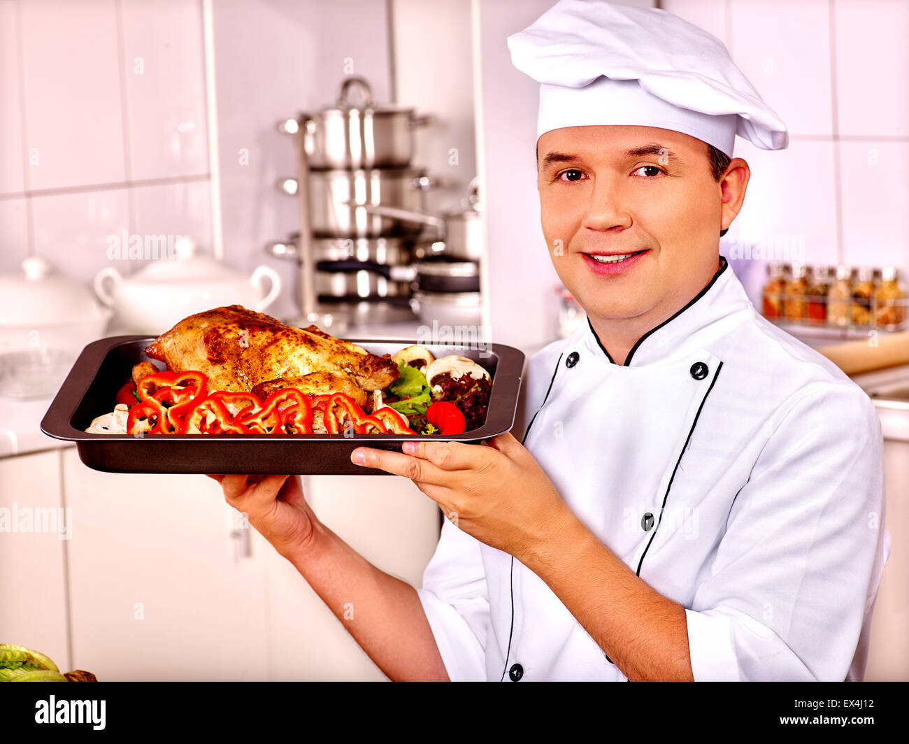 Man in chef hat cooking chicken Stock Photo - Alamy