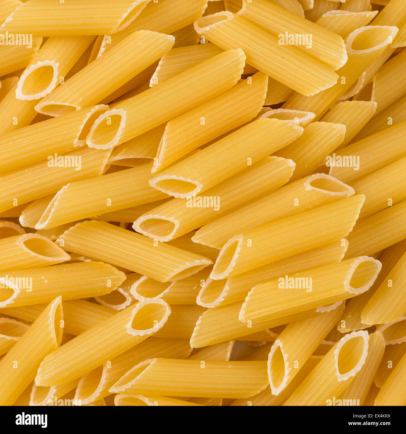 Closeup photo of uncooked italian penne pasta background Stock Photo ...