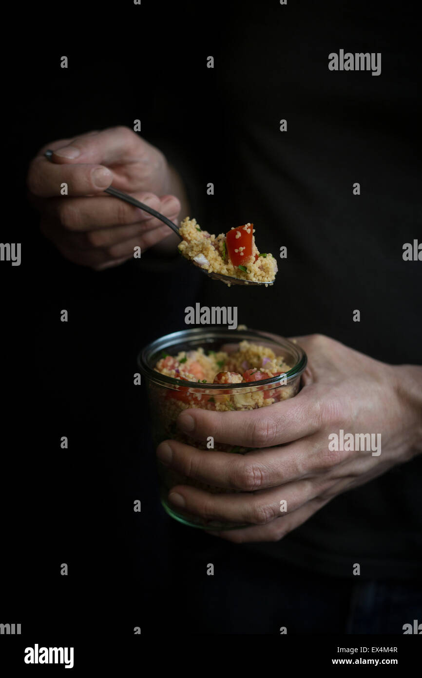 Hands holding a jar of couscous before dark background Stock Photo - Alamy