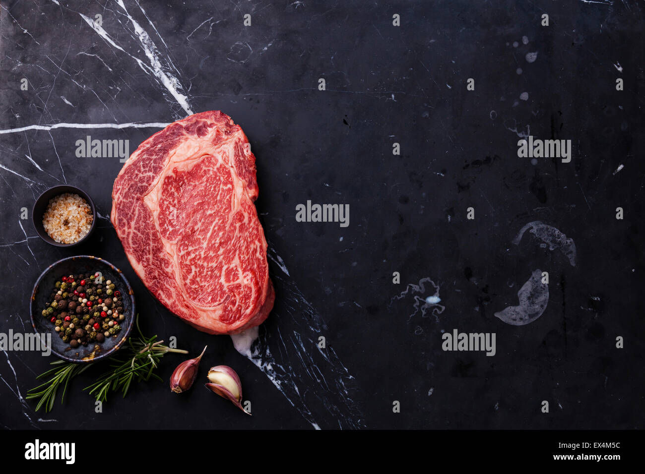 Raw fresh marbled meat Black Angus Steak Ribeye and seasonings on dark ...