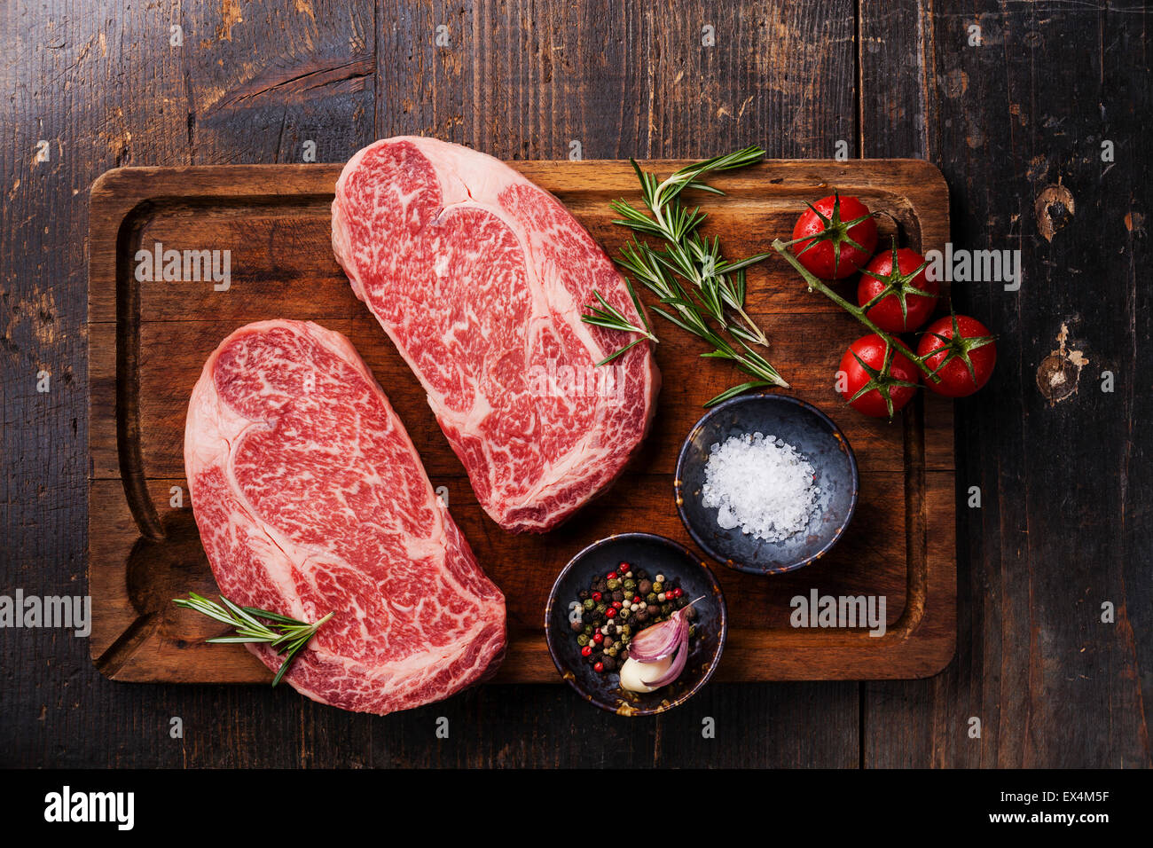 Two Raw fresh marbled meat Black Angus Steak Ribeye and seasonings on ...