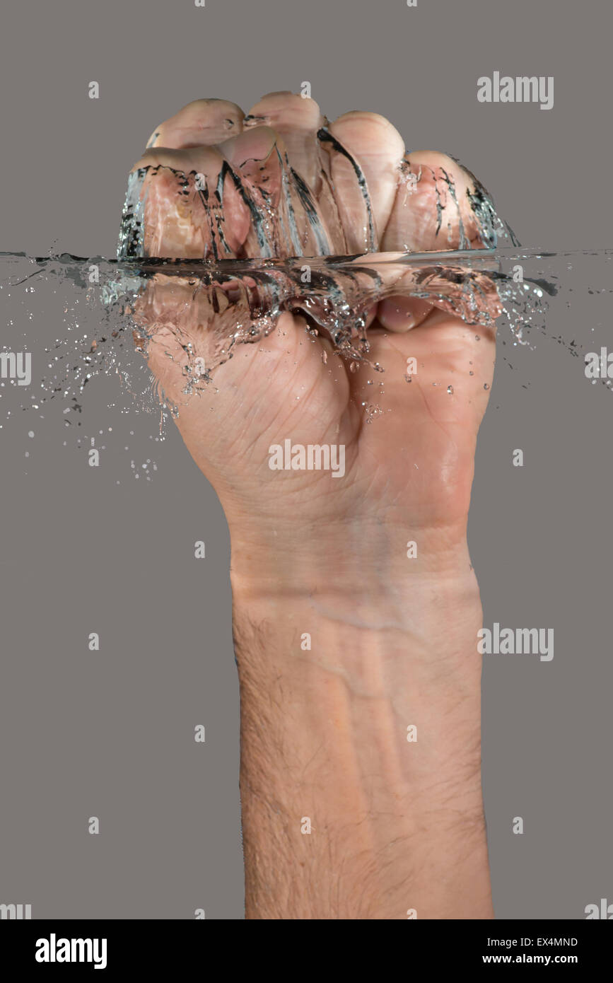 Fist punching up through water Stock Photo - Alamy