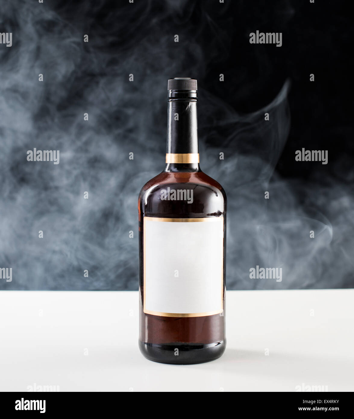 A brown glass alcohol bottle, set against a black background with smoke ...