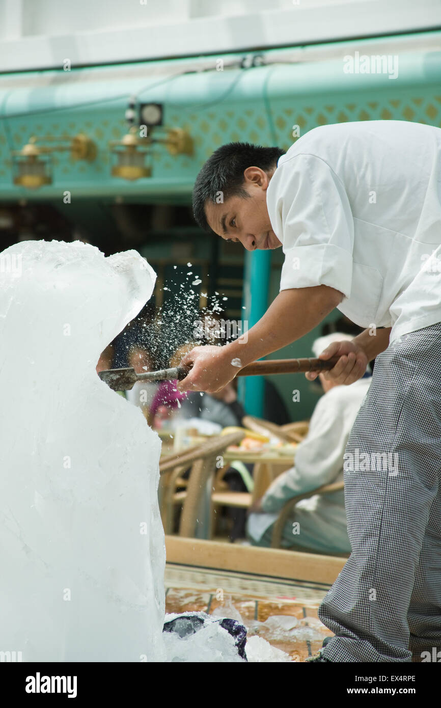 Chef using razor-sharp chisel to carve an ice sculpture of a sea horse ...