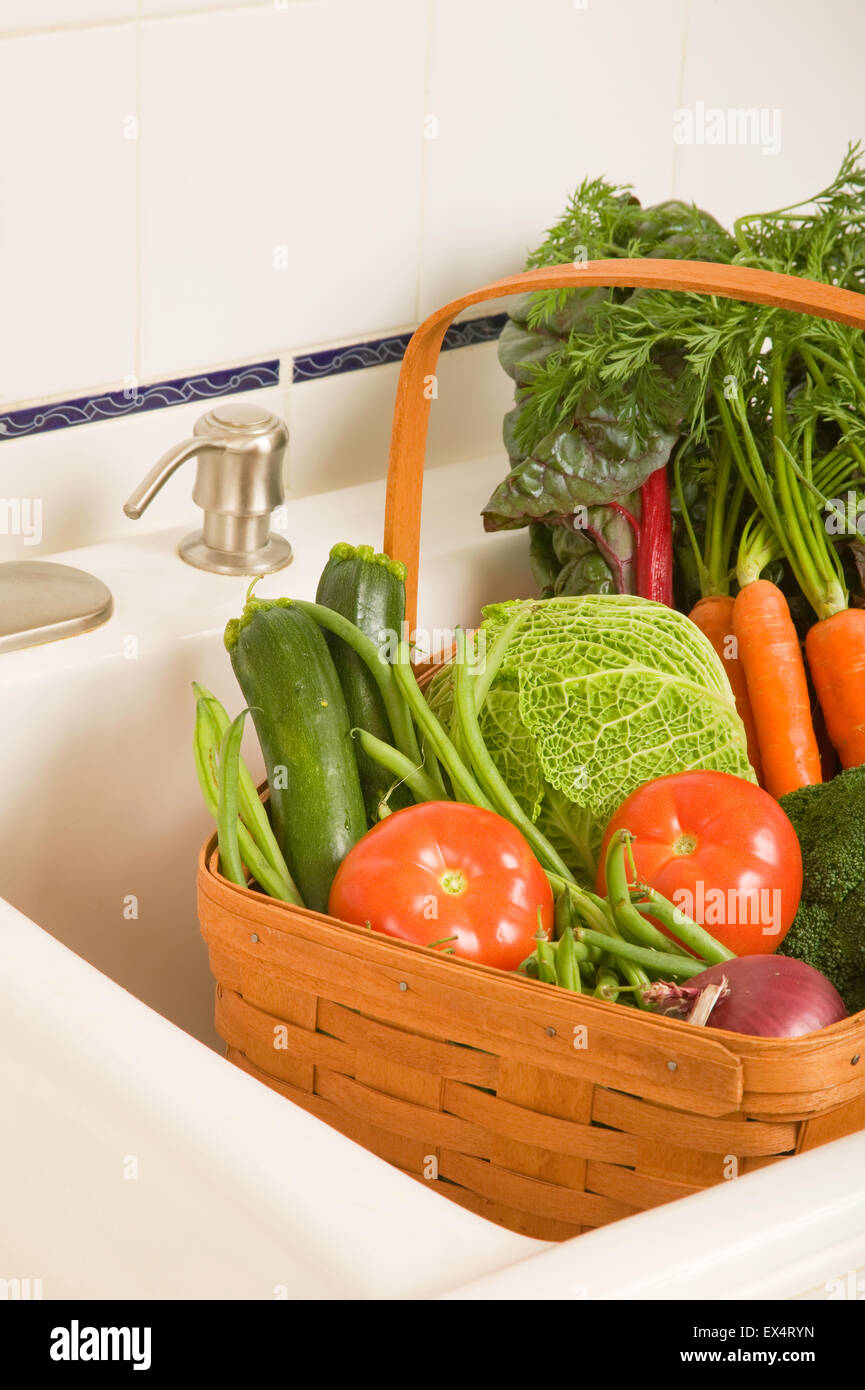 Basket of fresh produce in a kitchen with a white tile countertop Stock ...