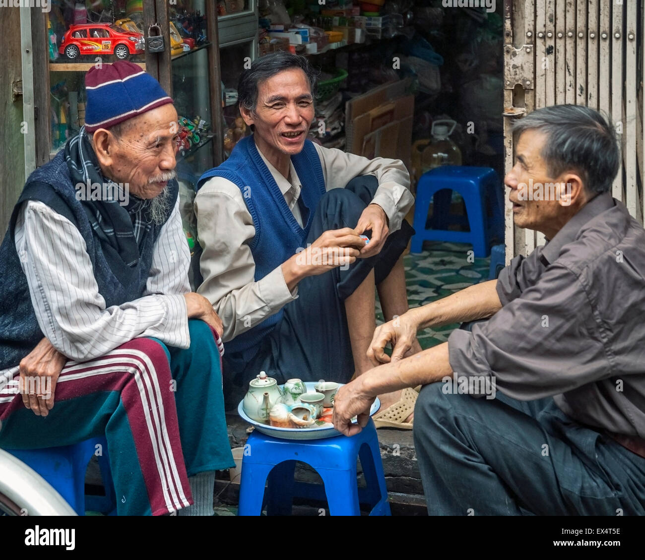 Men sitting on small plastic chairs in Hanoi, Vietnam Stock Photo - Alamy