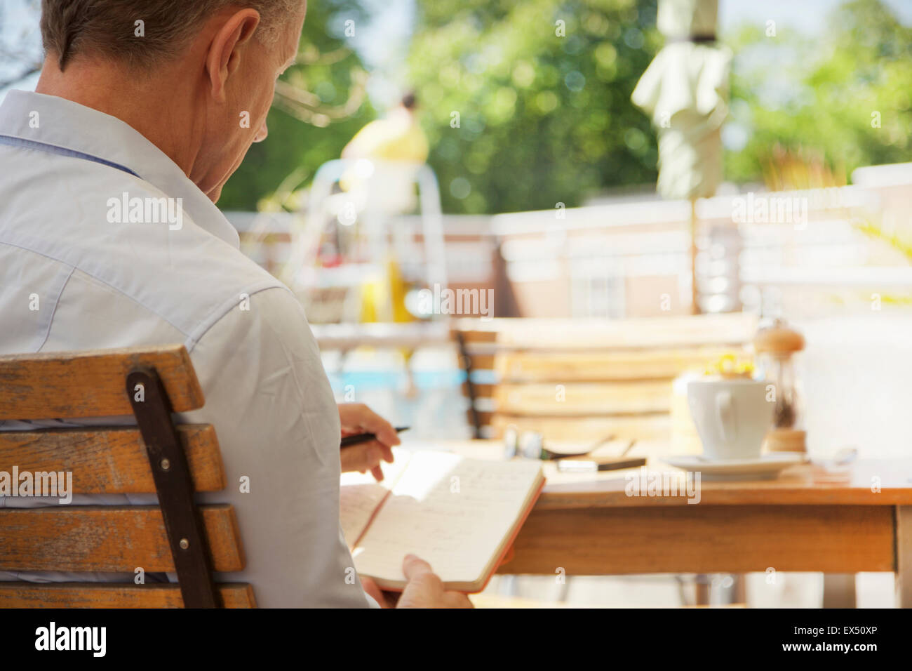 Mature man sitting chair behind table hi-res stock photography and ...
