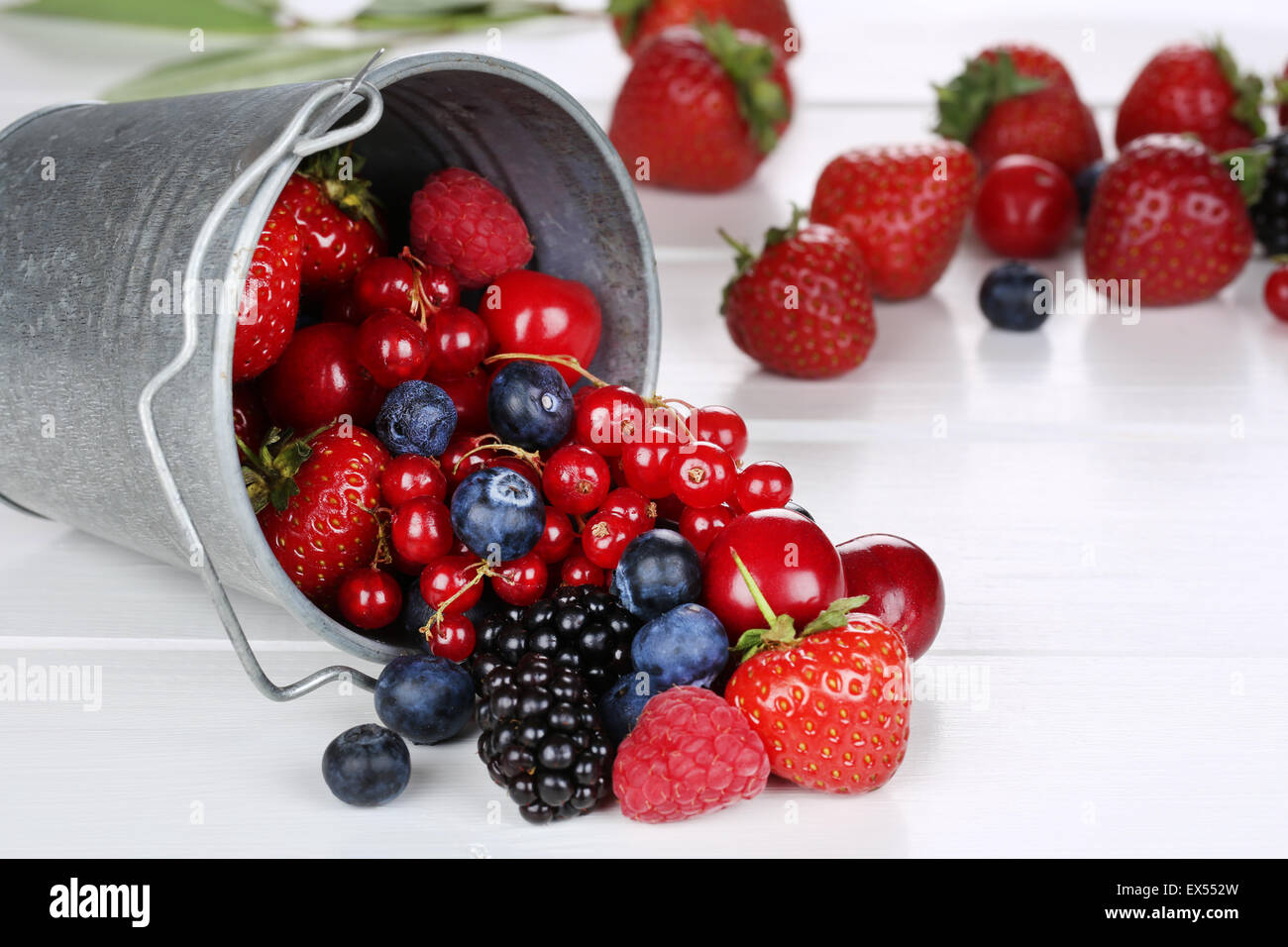 Berry fruits in bucket with strawberries, blueberries, red currants ...