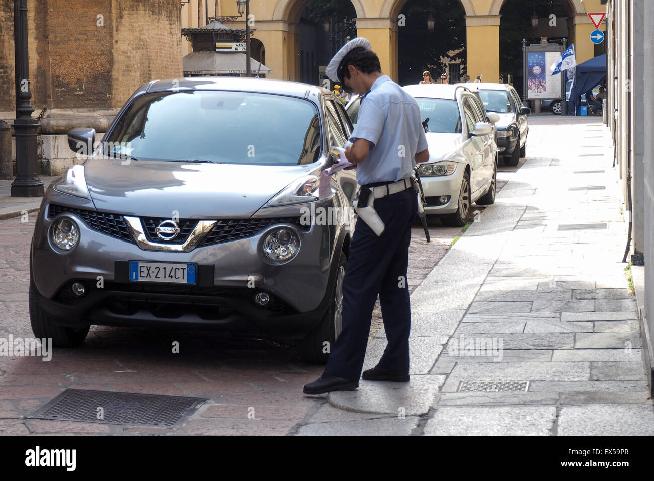 A parking inspector writing a parking ticket Stock Photo - Alamy