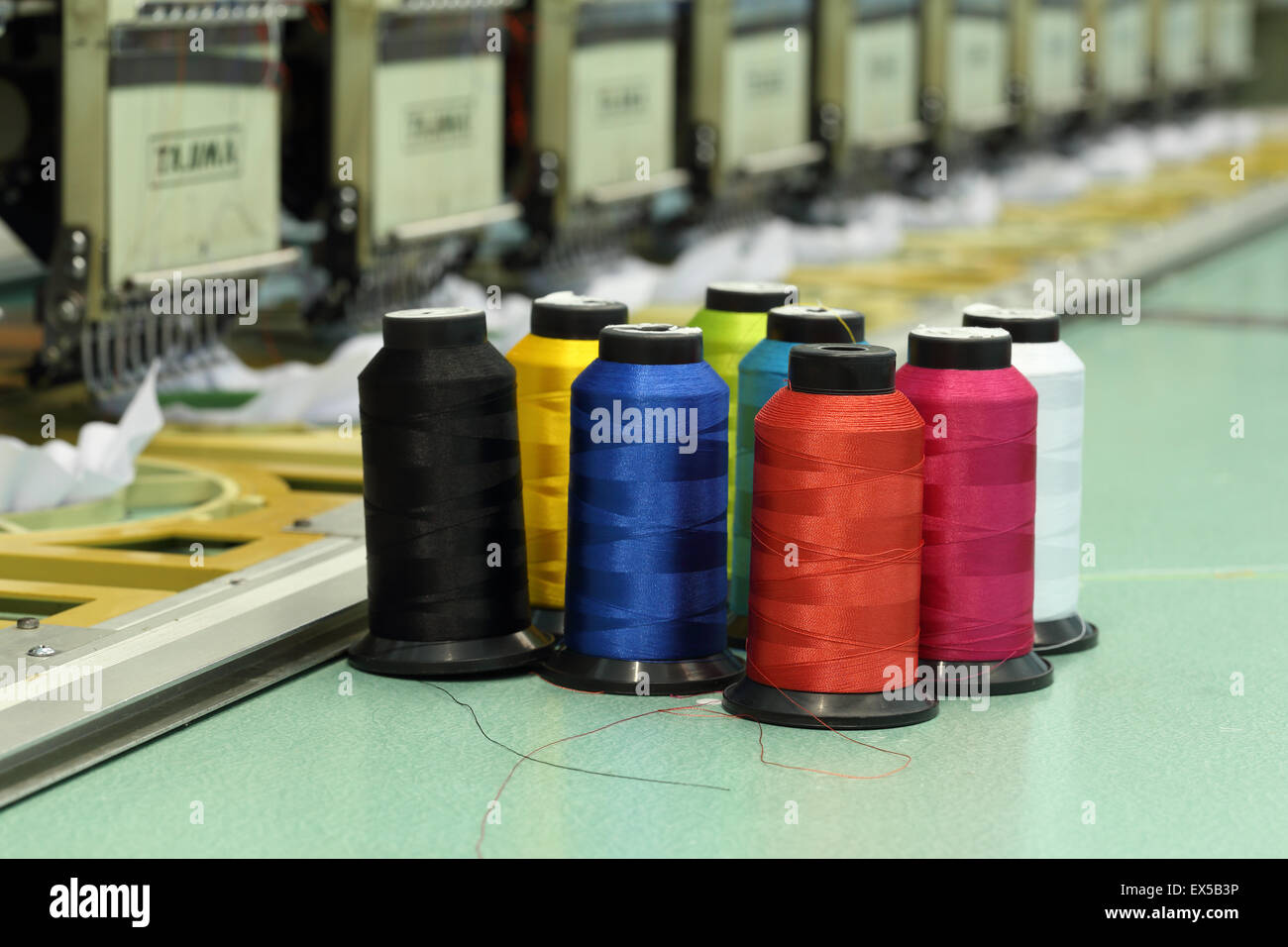 reels of thread with Machine embroider background Stock Photo - Alamy