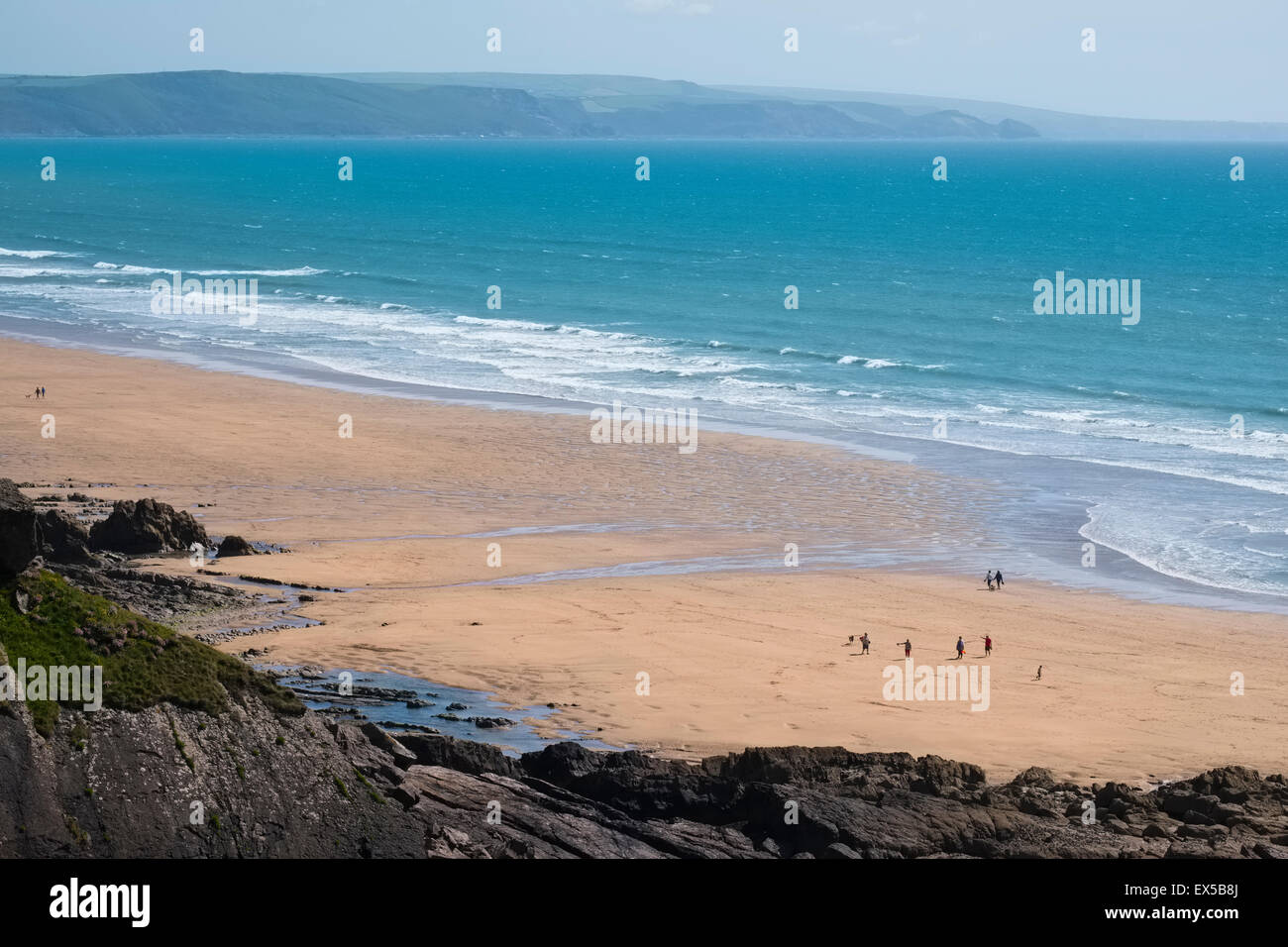 People walking on the beach along the Cornish coast at Bude, Cornwall ...