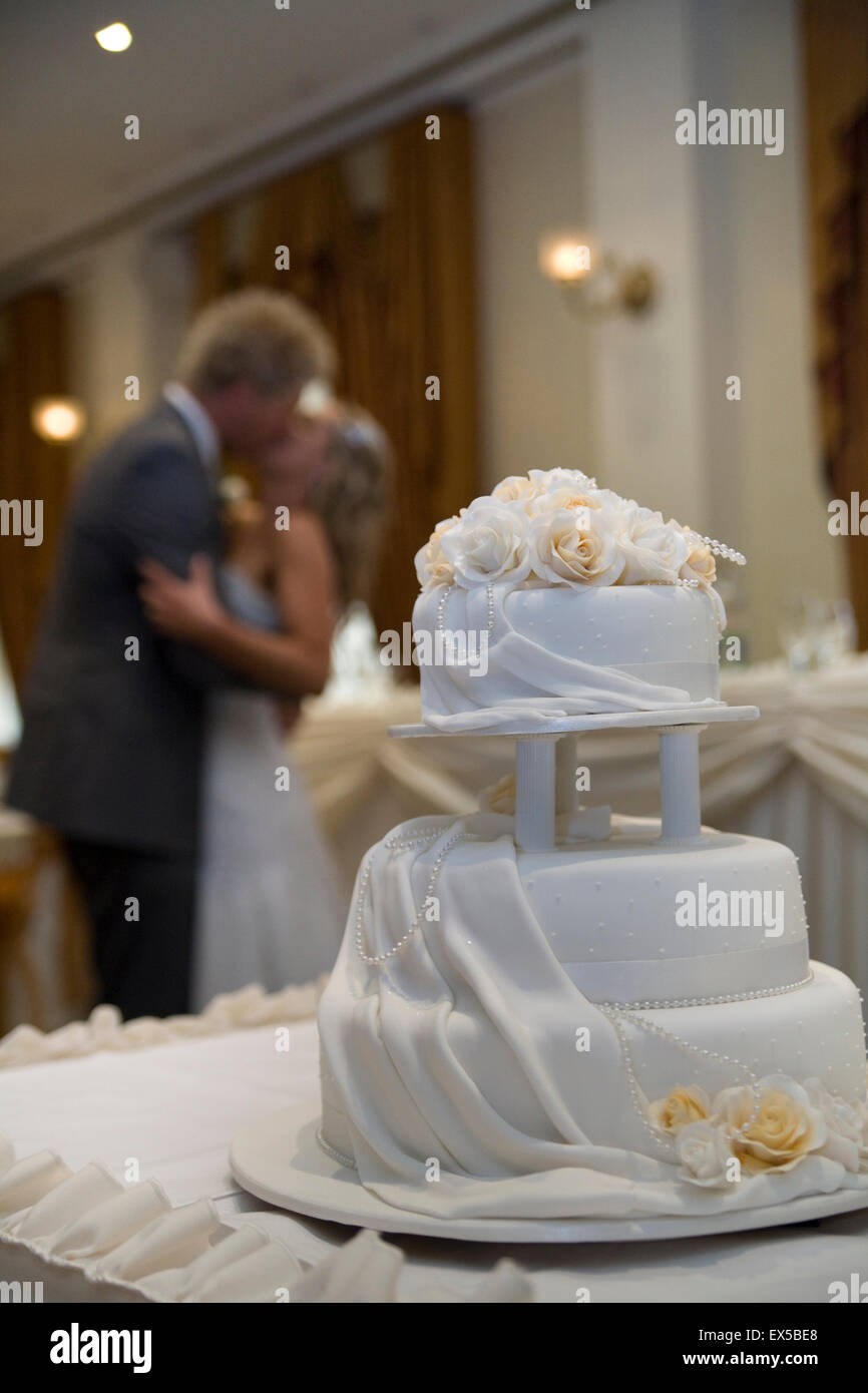 Decorated wedding cake with the couple kissing in the background Stock ...