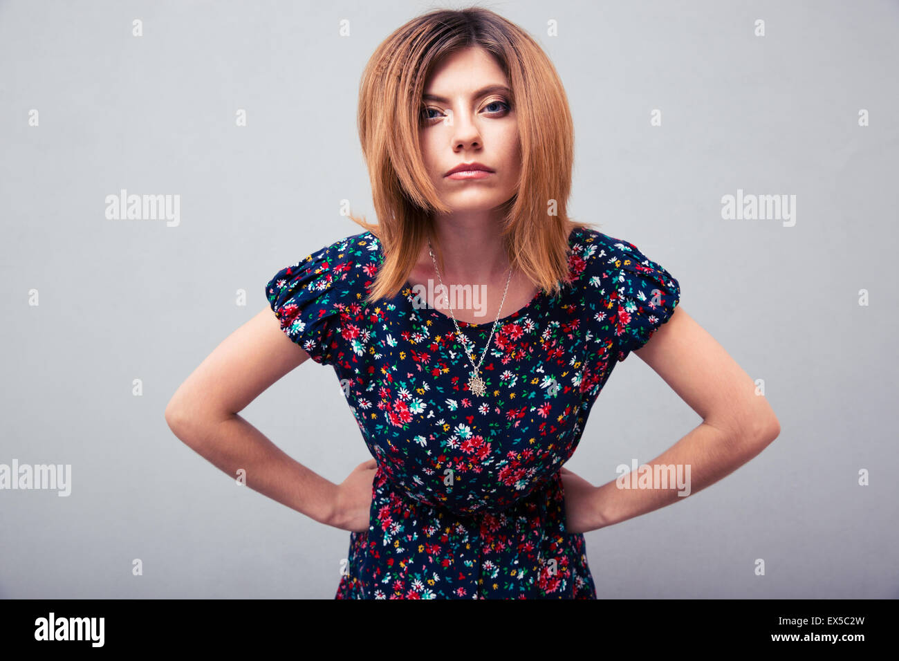 Portrait of angry woman looking at camera over gray background Stock ...