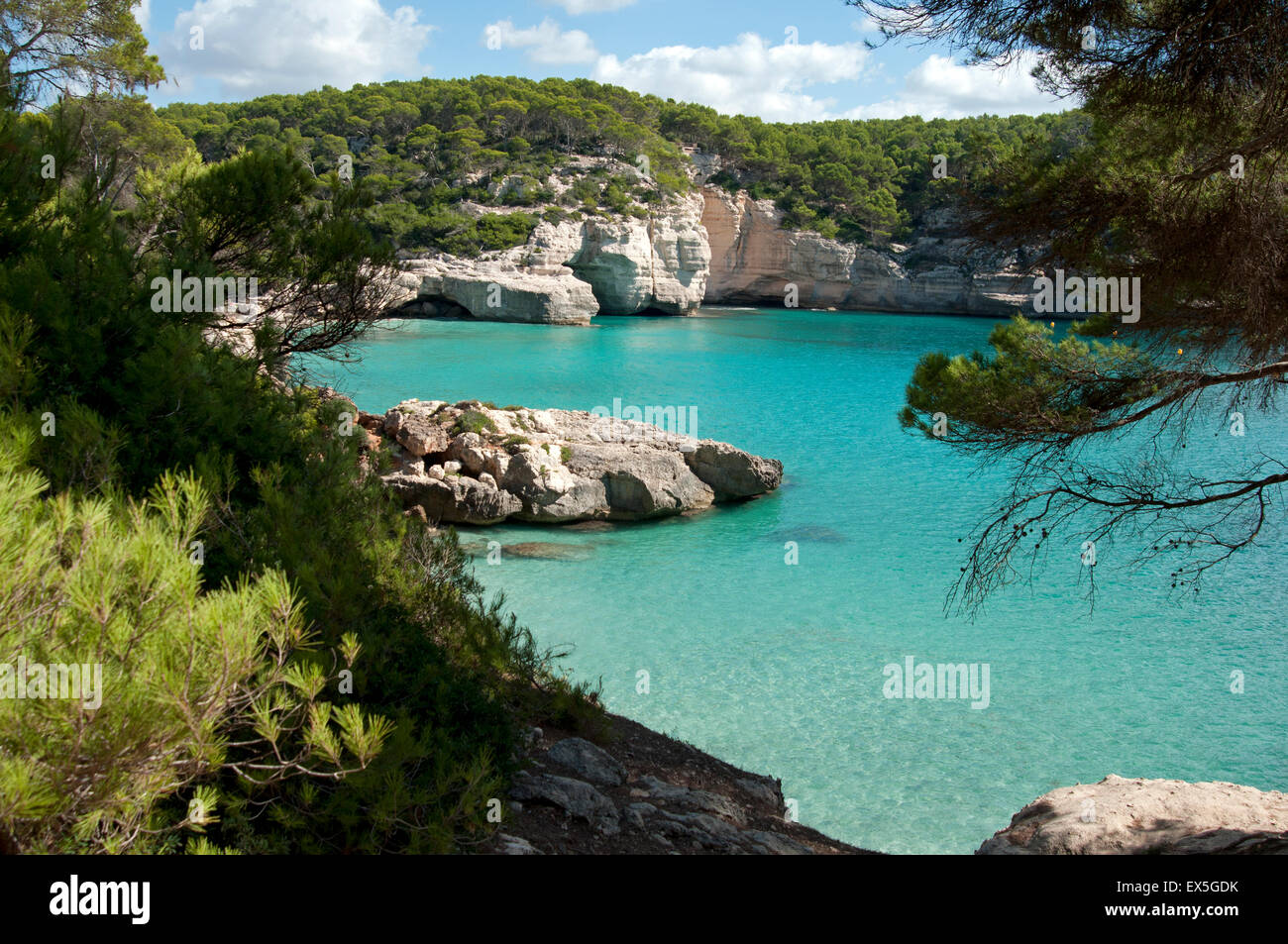 The clear azure waters of cala Mitjana from the cliffs above on the ...