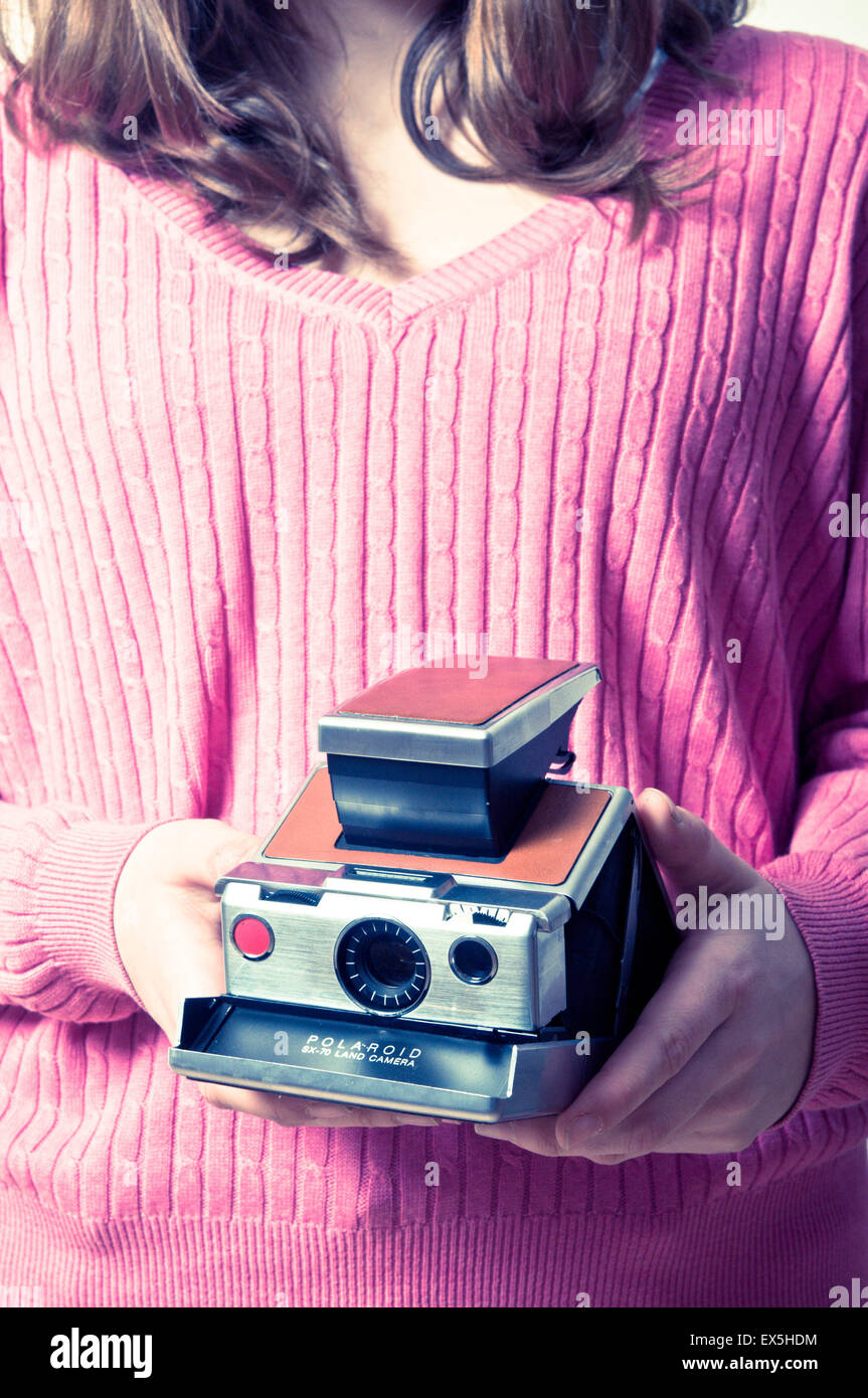 tween girl holding a Polaroid SX70 camera Stock Photo - Alamy