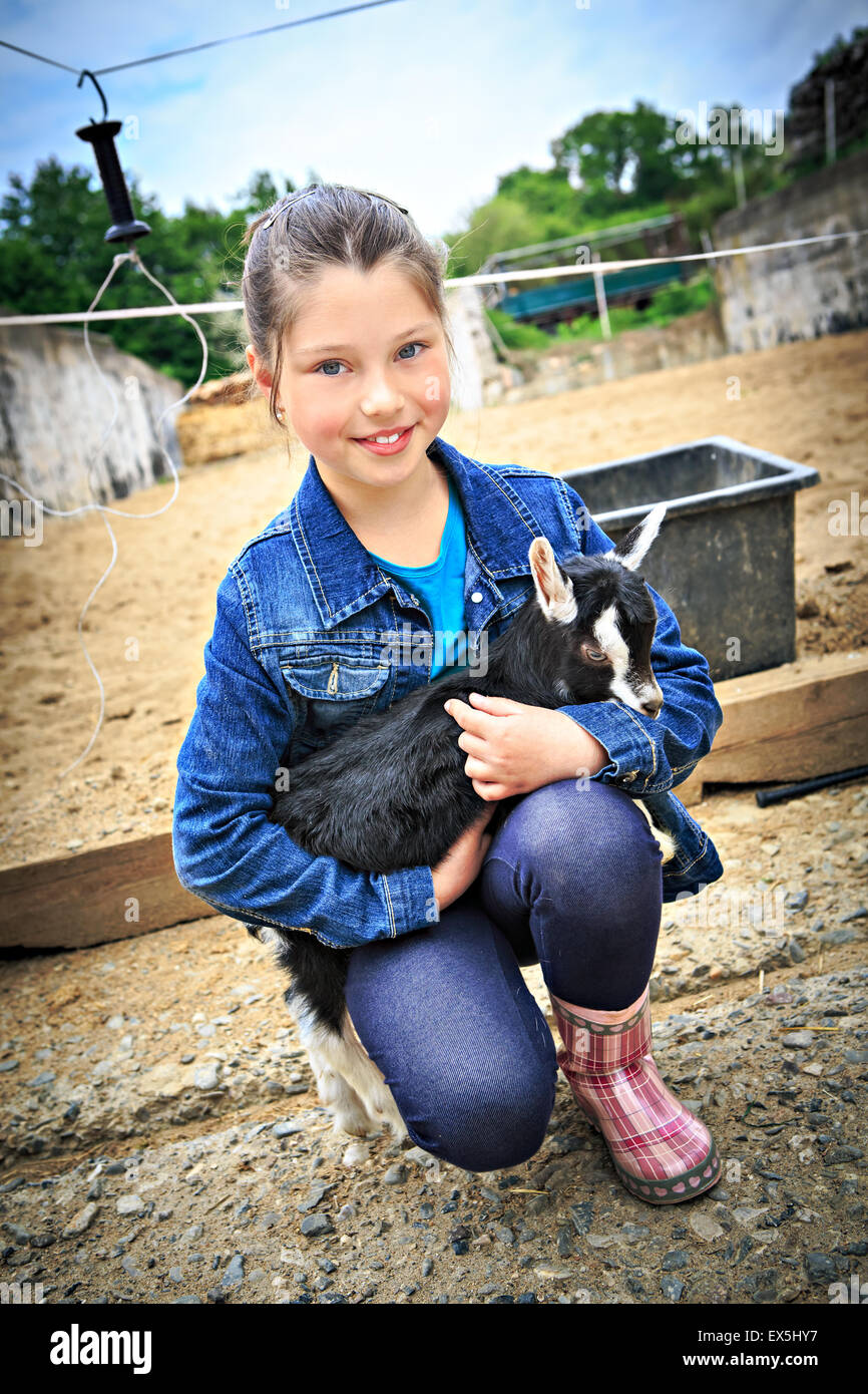 little girl with a goat kid in front of the farm Stock Photo - Alamy