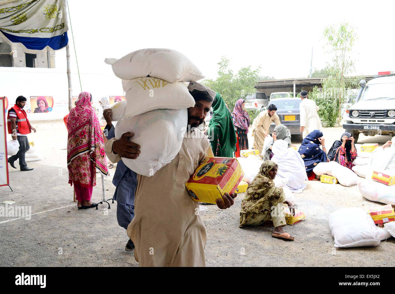Volunteers distribute relief goods among needy people during ...