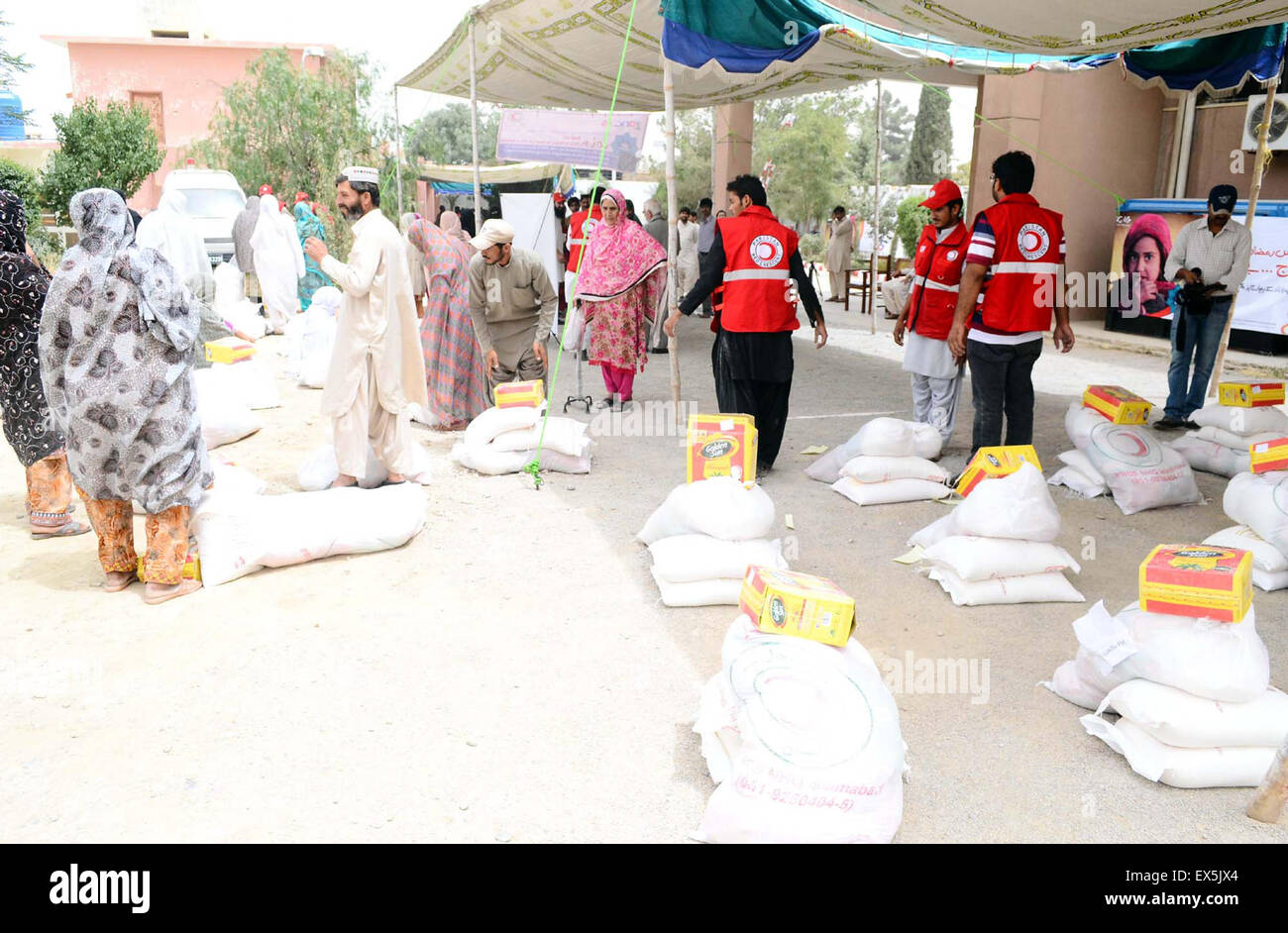 Volunteers distribute relief goods among needy people during ...