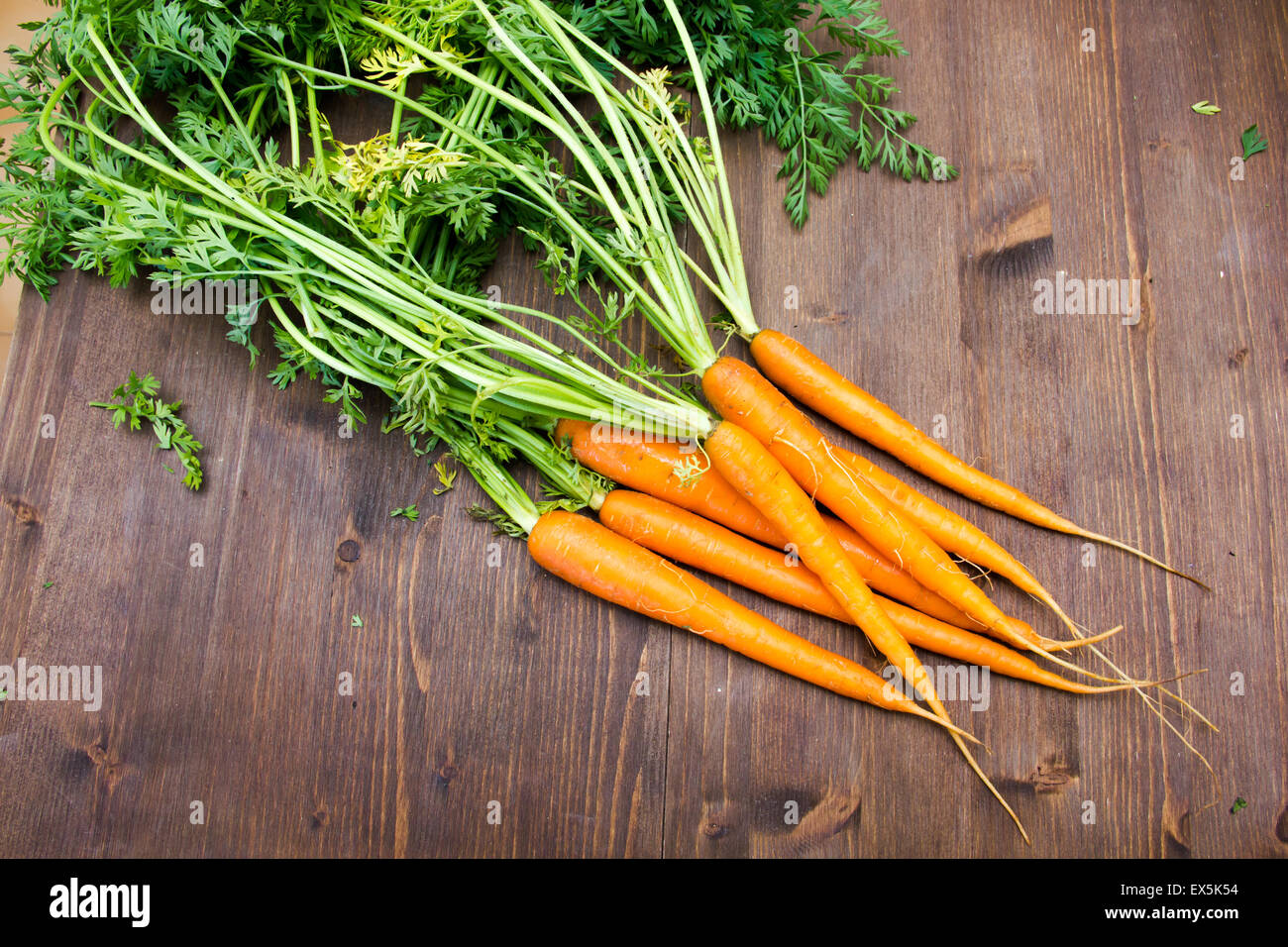 Fresh carrots arranged on dark wood table Stock Photo - Alamy