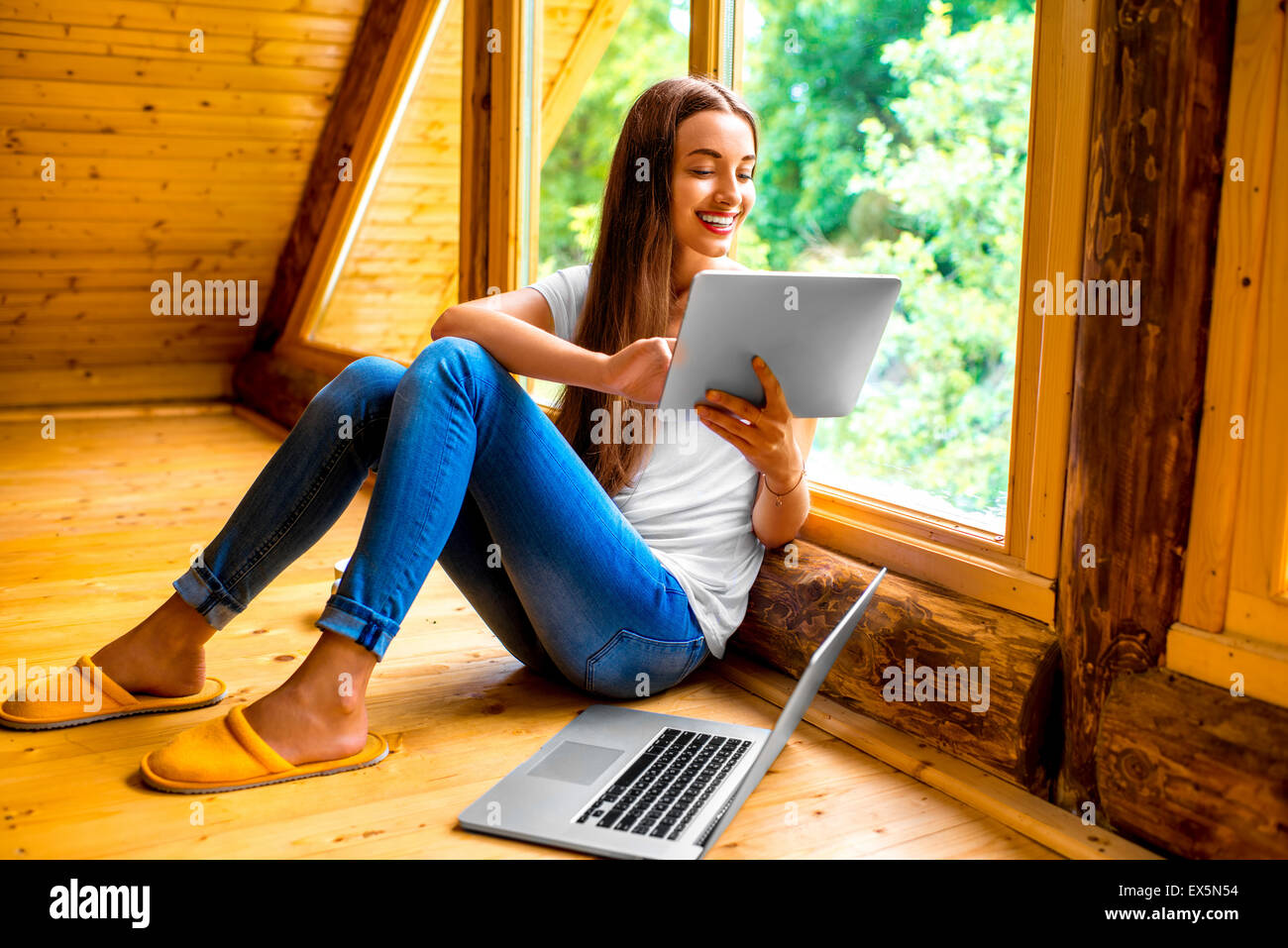 Woman with tablet near the window in cottage Stock Photo - Alamy