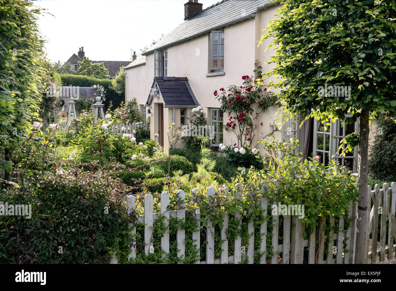 Exterior facade of an English country cottage with picket fence and ...