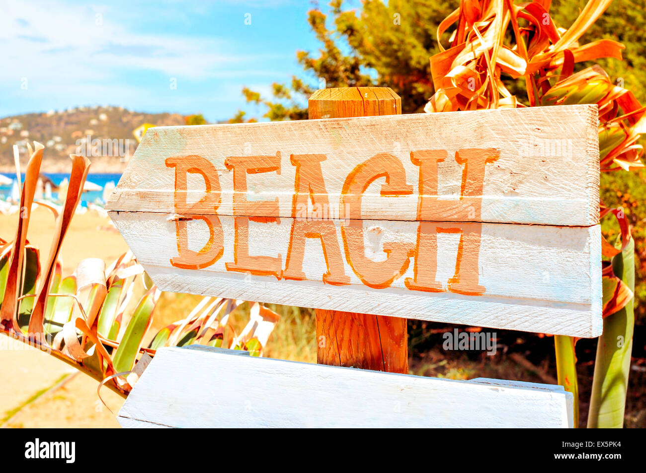 closeup of a wooden signpost with the text beach written in it, in ...