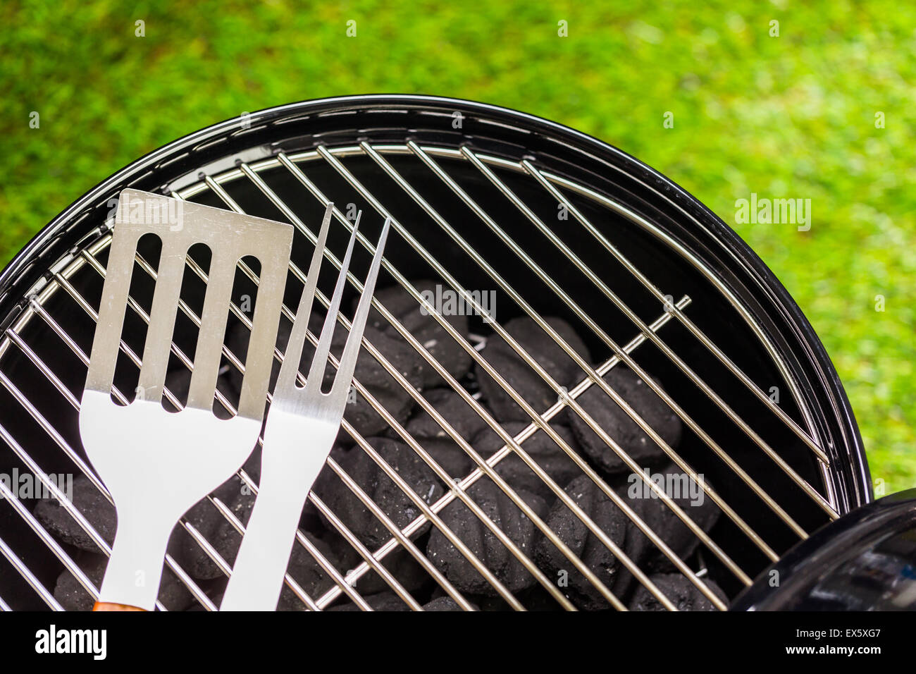 Small round charcoal grill ready for grilling at the summer picnic ...