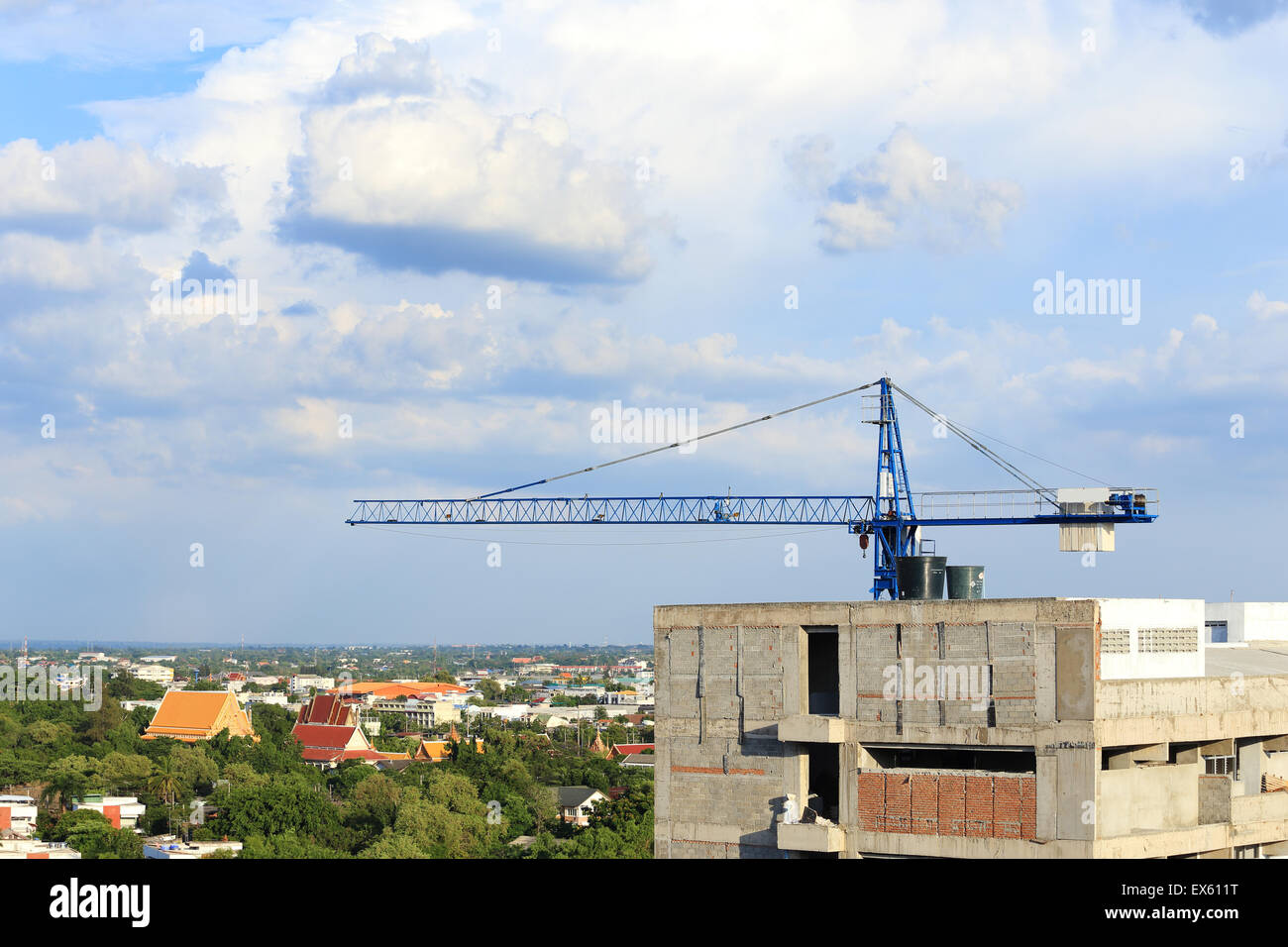 Industrial Crane on a building with city and sky background Stock Photo ...