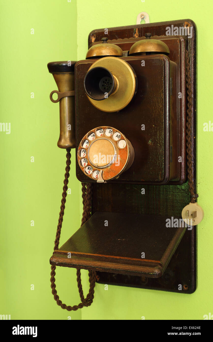 old classic wood telephone hanging on green wall Stock Photo - Alamy