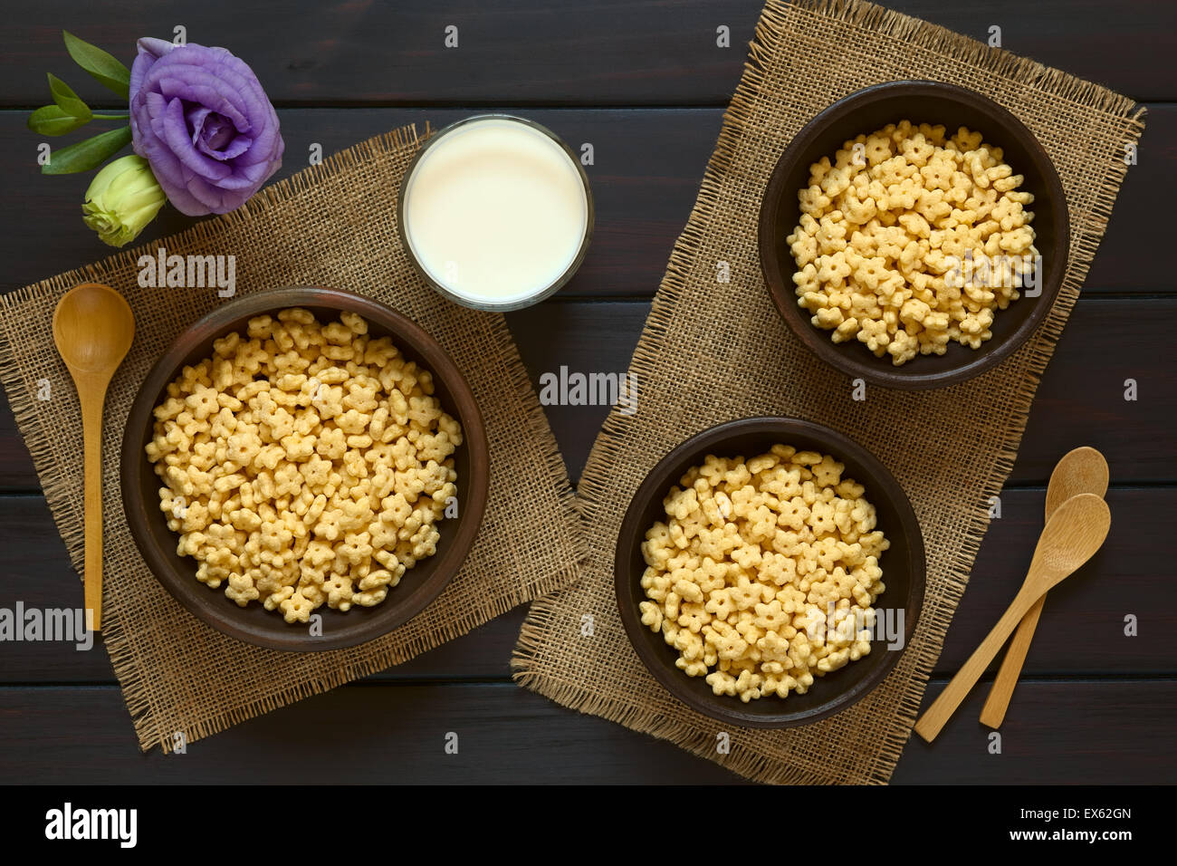Honey flavored breakfast cereal in three rustic bowls with a glass of ...