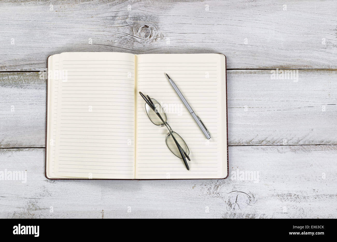 Vintage white desktop with notepad, pen and reading glasses. High ...