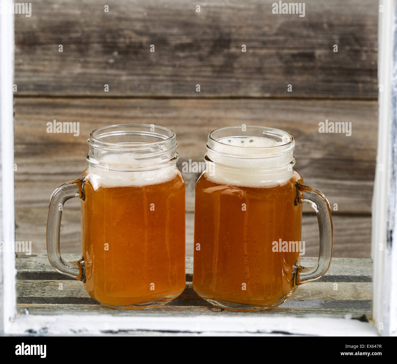 View through windows of two glass jars filled with frosty cold beer on ...