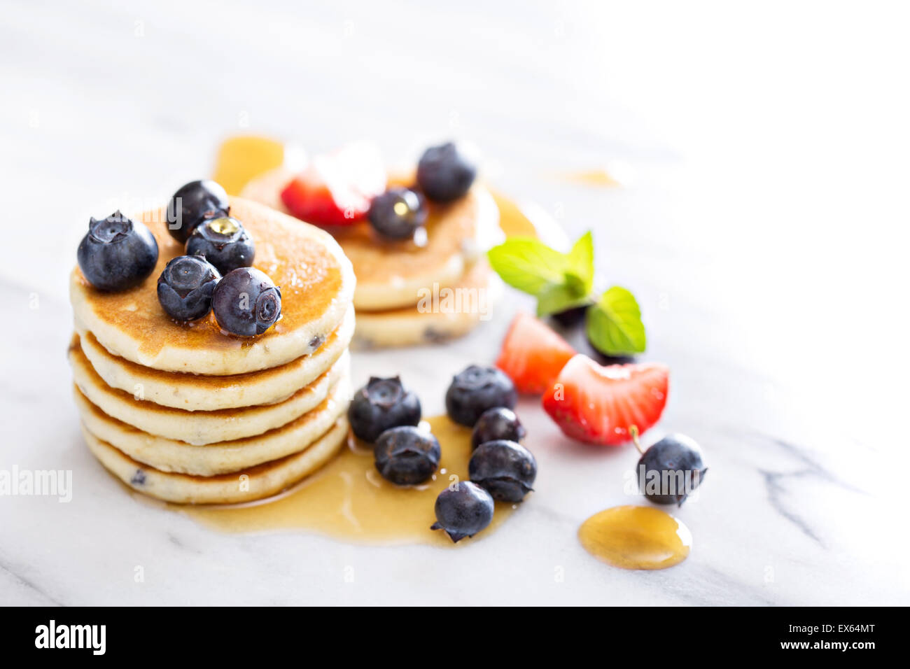 Stack of small pancakes with berries on marble board Stock Photo - Alamy