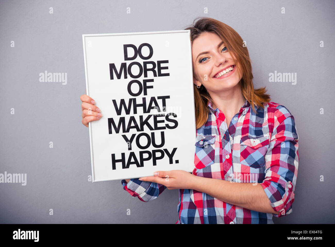 Happy woman in casual cloth holding board with motivational phrase over ...